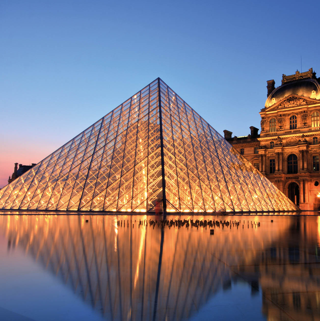 Editorial: PARIS, FRANCE - JULY 6: The Louvre Pyramid at dusk during ...